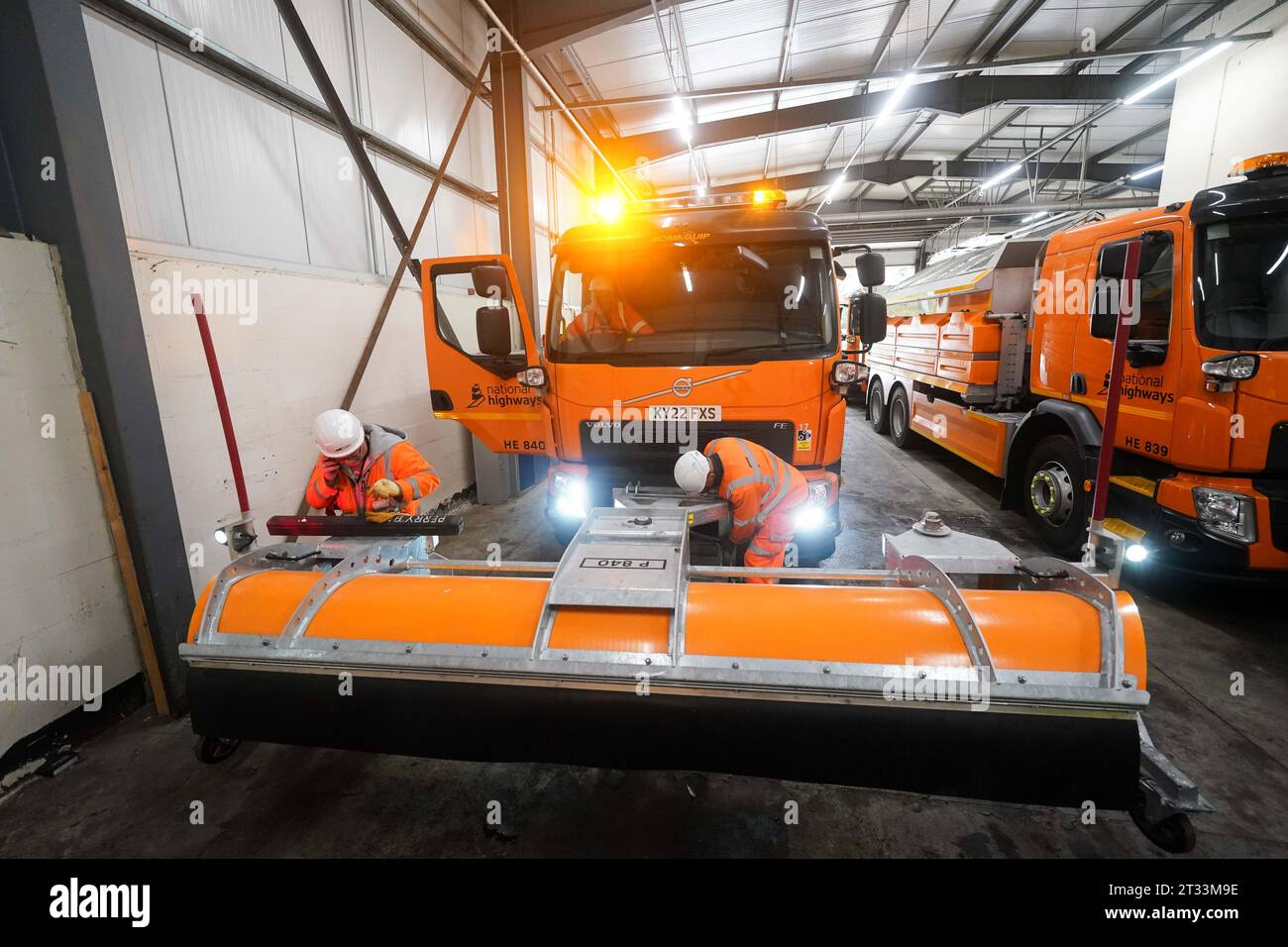 National Highways staff attach a plough to a winter service vehicle at ...