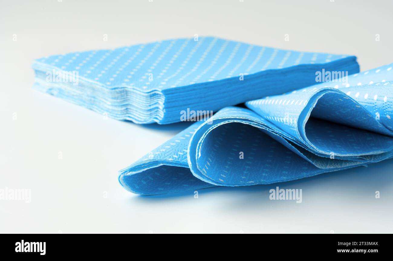 Stack of blue dotted paper napkins isolated on white Stock Photo - Alamy