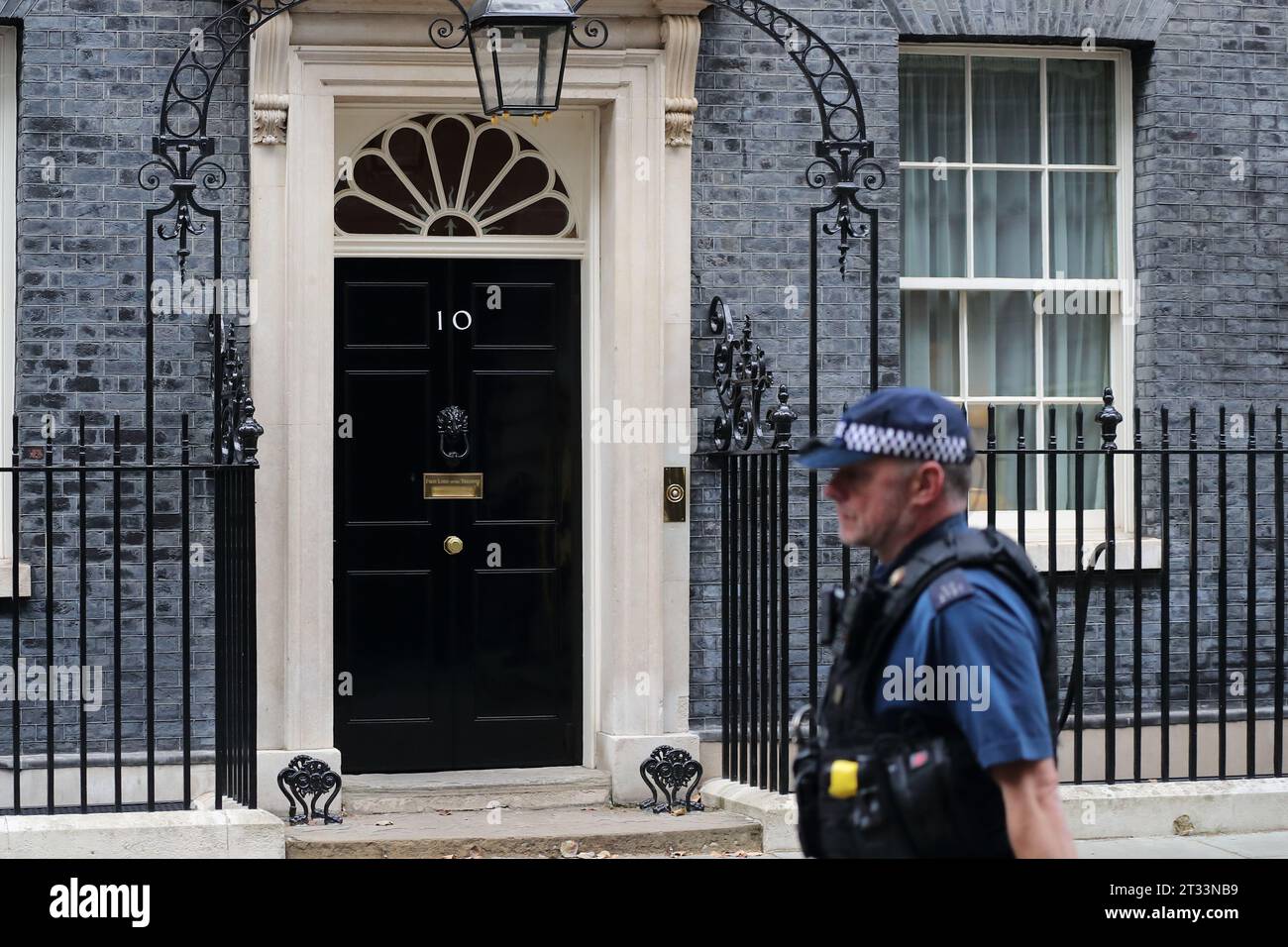 An armed police officer walks past the entrance to No 10 Downing Street ...