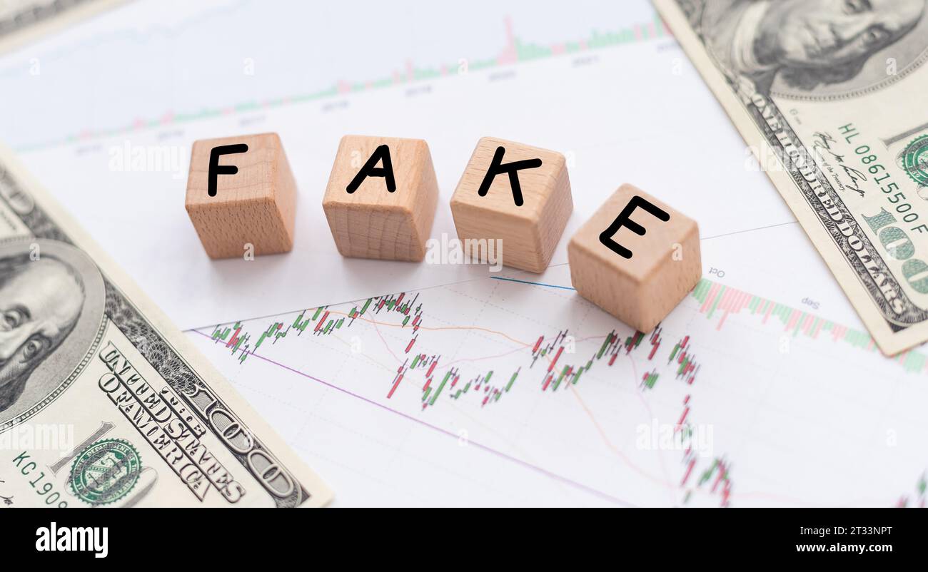 The word 'fake' written on wooden blocks, a man sitting in front of his ...