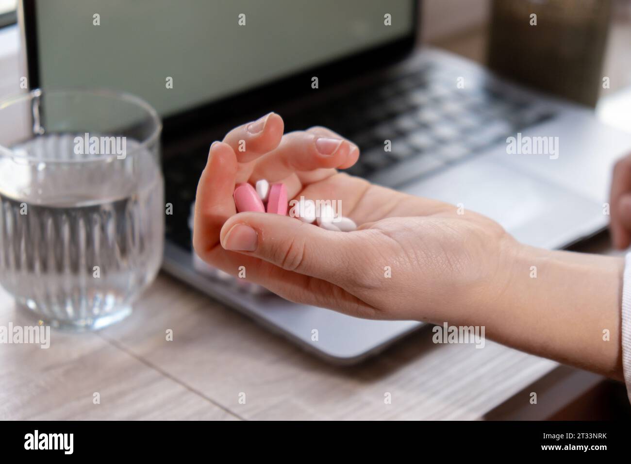 Woman taking Daily vitamins white working on laptop Organizer weekly ...