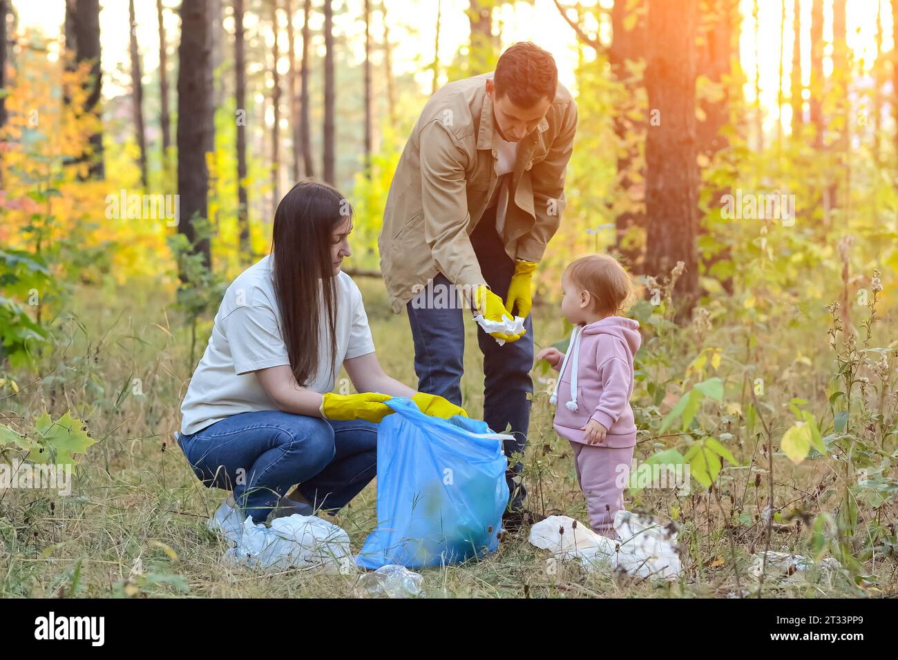 Family helps environment by picking up trash in park Stock Photo - Alamy