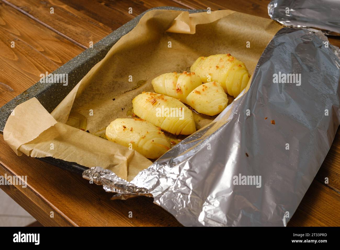 Process of baking whole half slices potato in oven Stock Photo - Alamy