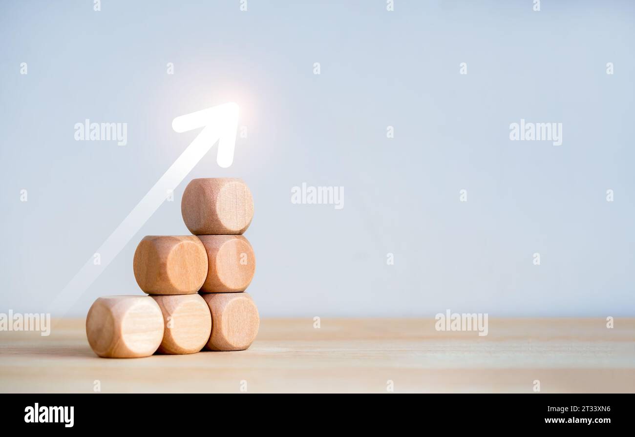 Rise up glowing arrow on wooden cube blocks as a business chart steps ...