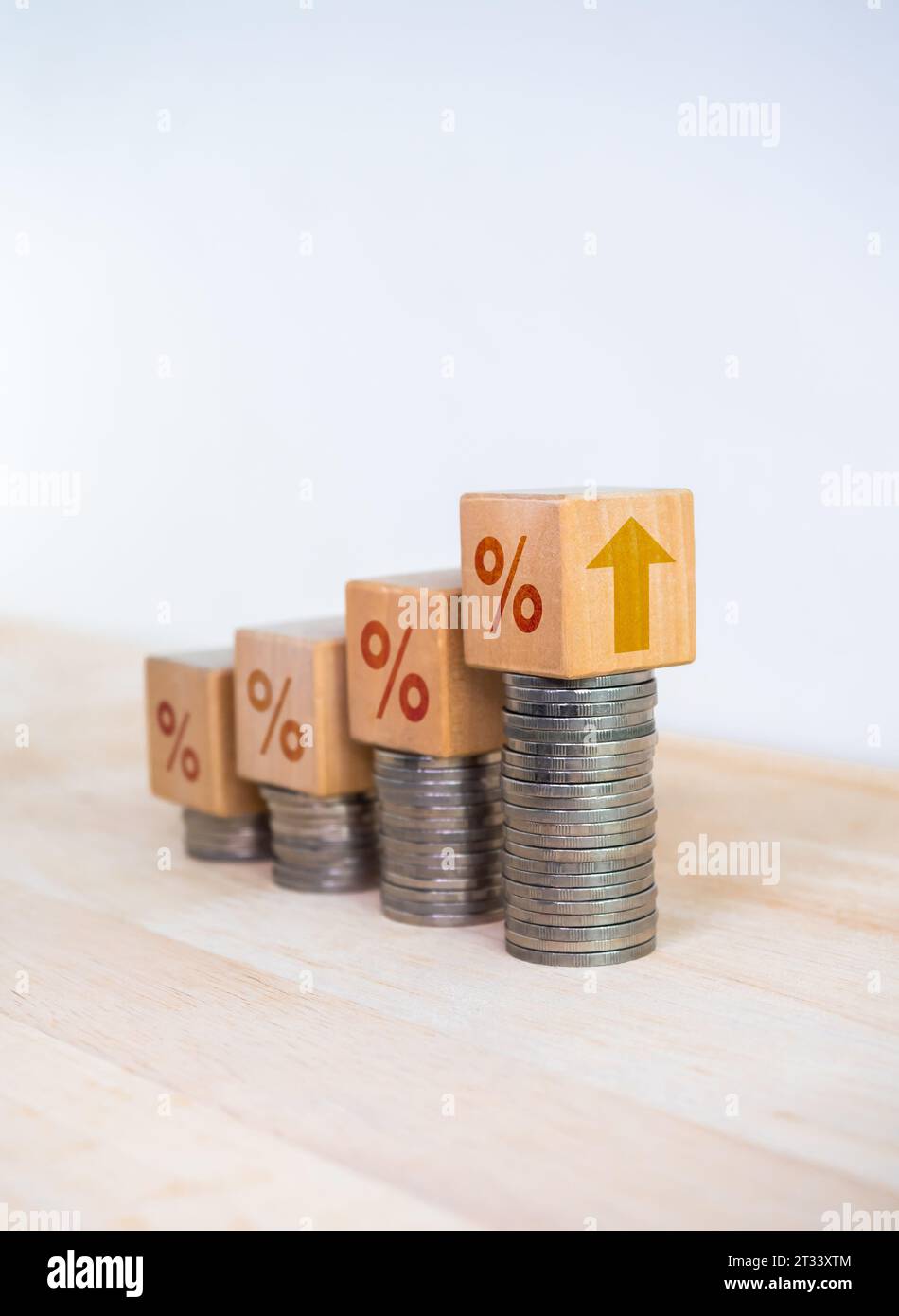 Percentage icon and up arrow on wooden cube blocks on coin stacked bar ...