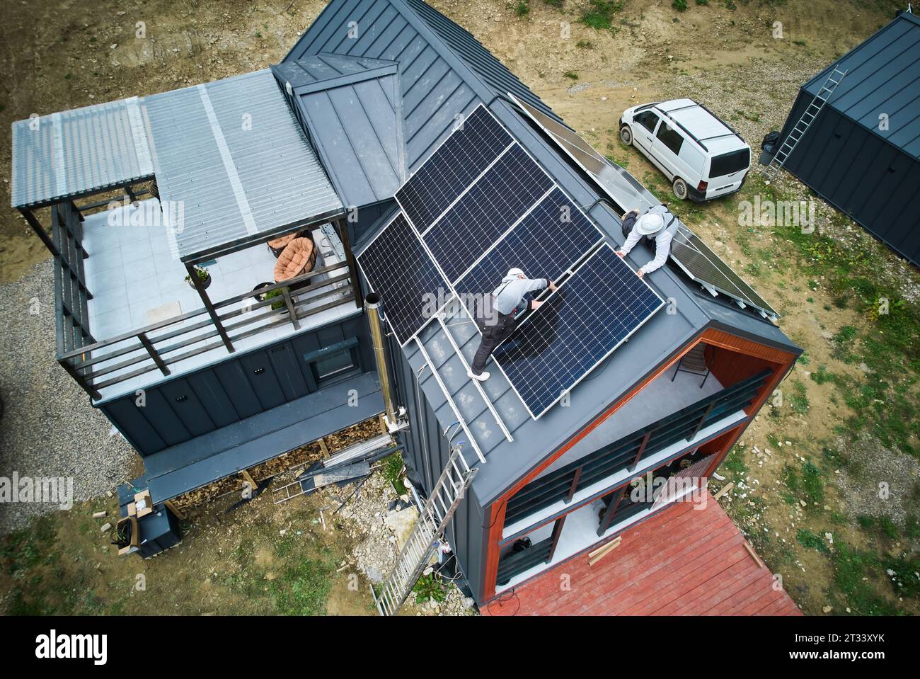 Electricians connecting cables while installing photovoltaic solar ...