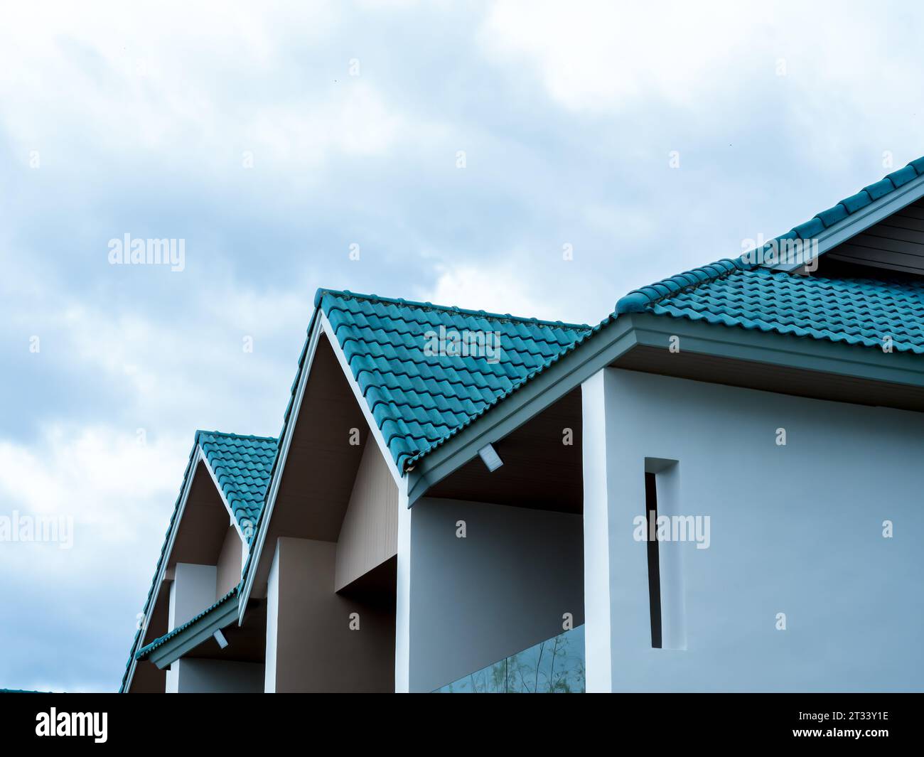 Blue green gable roof of the big modern white house building on blue ...