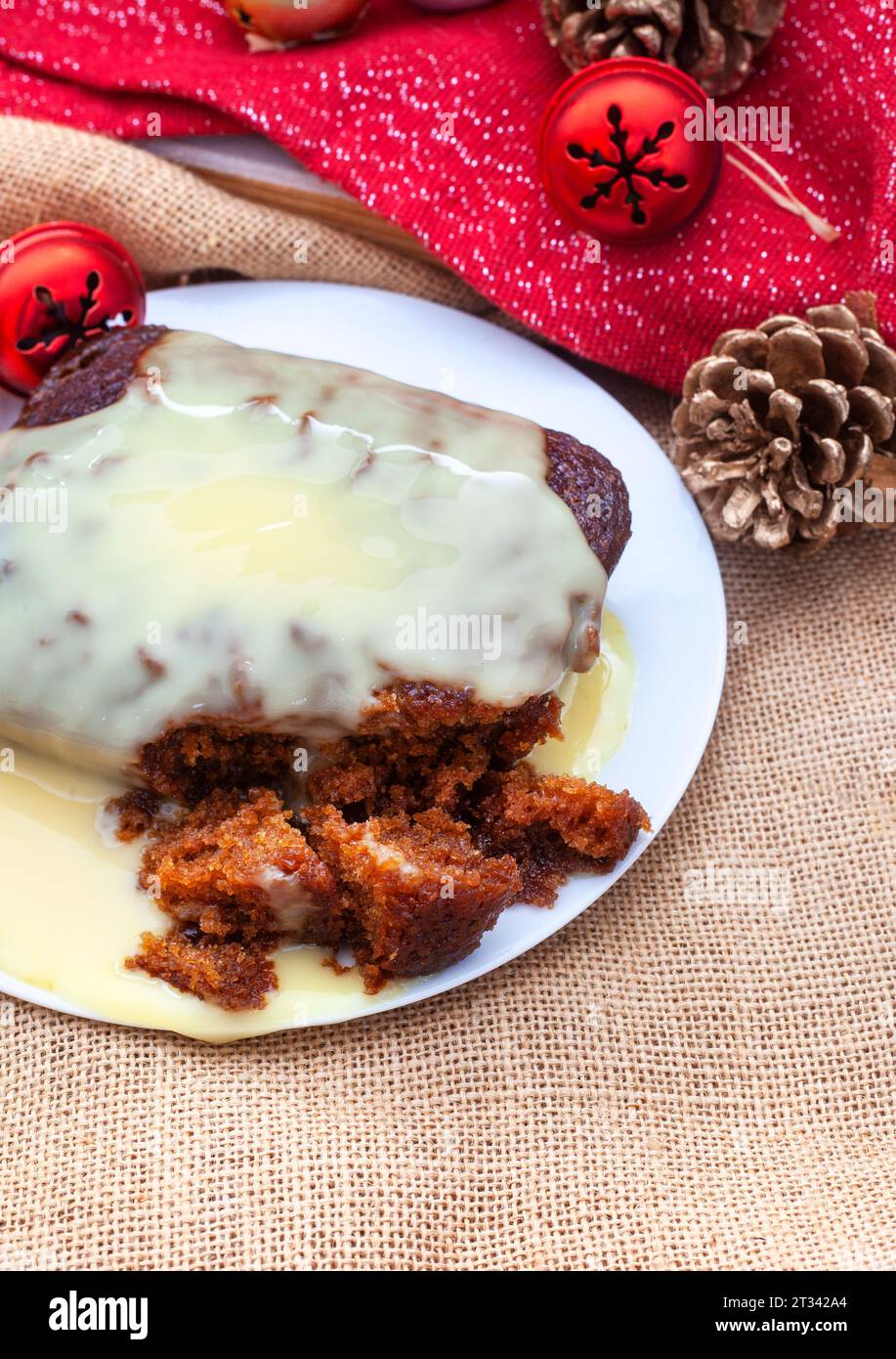 Traditional South African Malva pudding with creamy custard on rustic ...