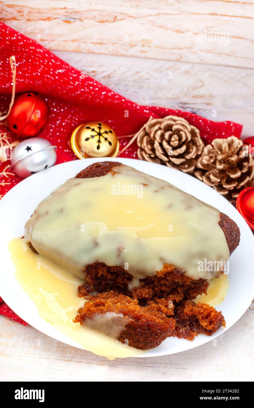 Traditional South African Malva pudding with creamy custard on rustic ...