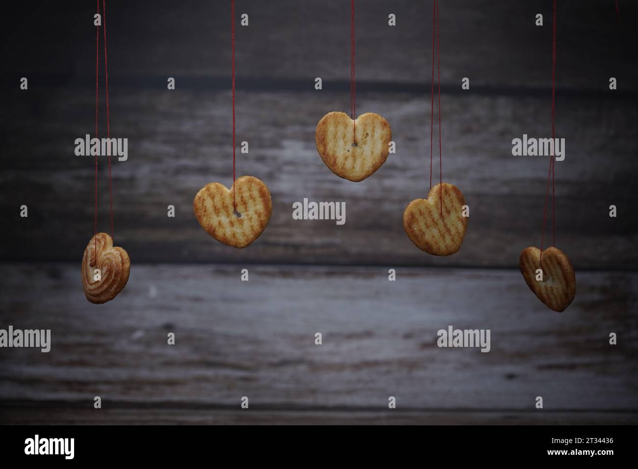 A few love shaped biscuits are hanging on the string Stock Photo - Alamy