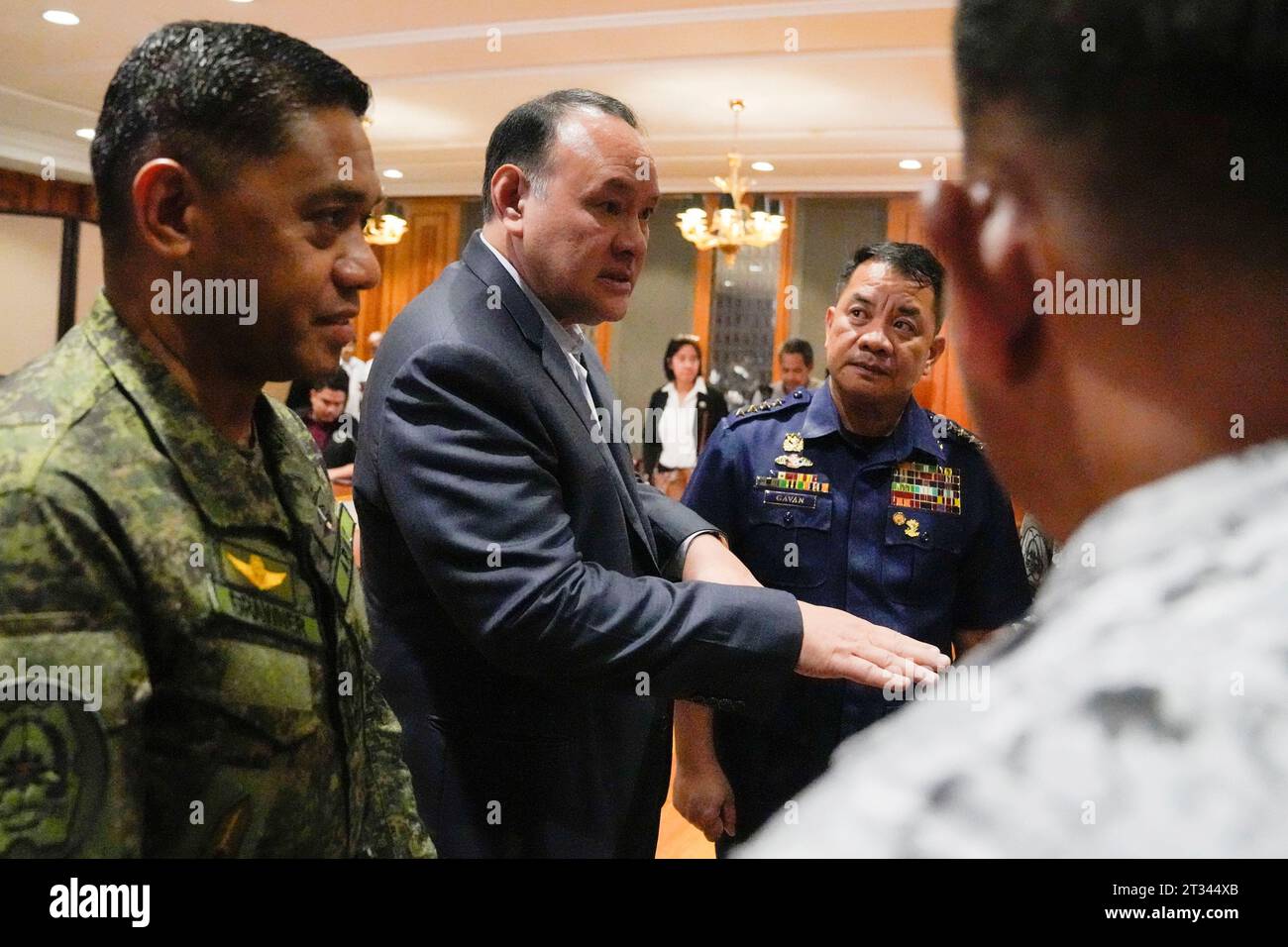 Philippines Defense Secretary Gilbert Teodoro, center, talks with ...