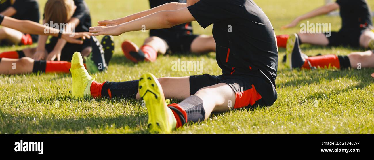 School kids stretching on the grass sports pitch. Group of soccer ...