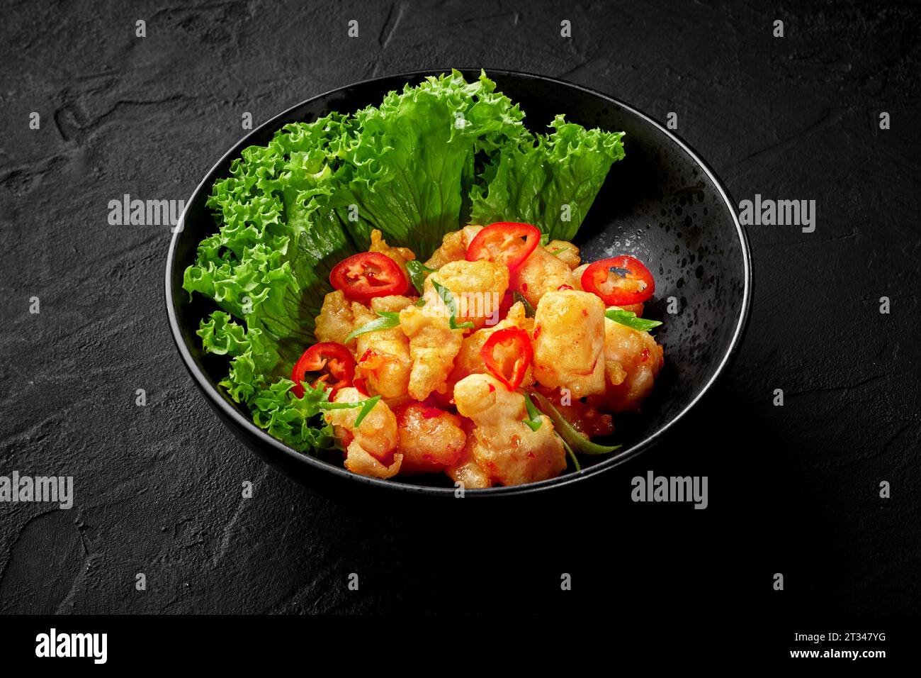 Wok fried basa fish pieces in batter with lettuce and chili pepper ...