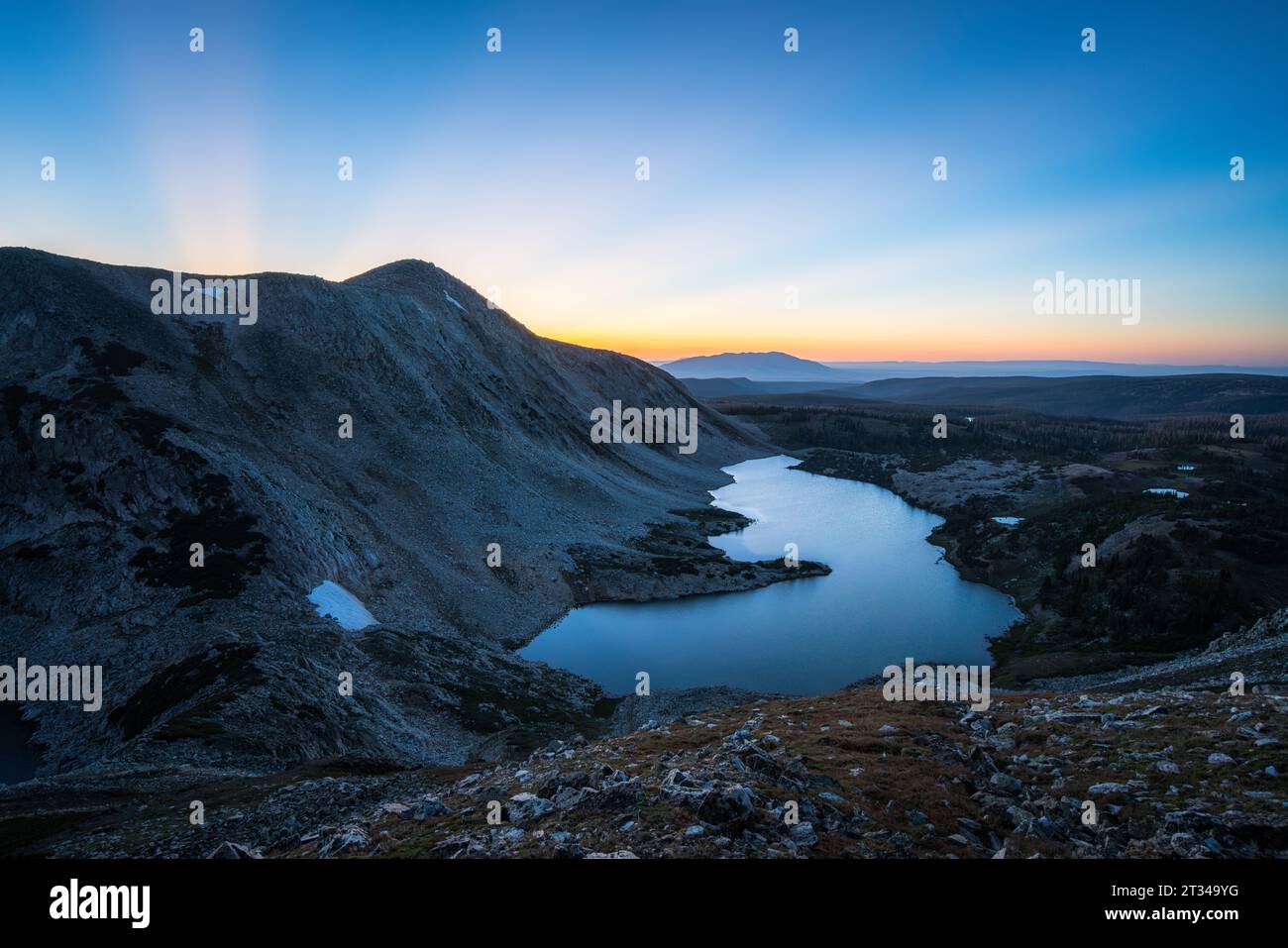 Alpine lake and sun beams in snowy range Stock Photo - Alamy