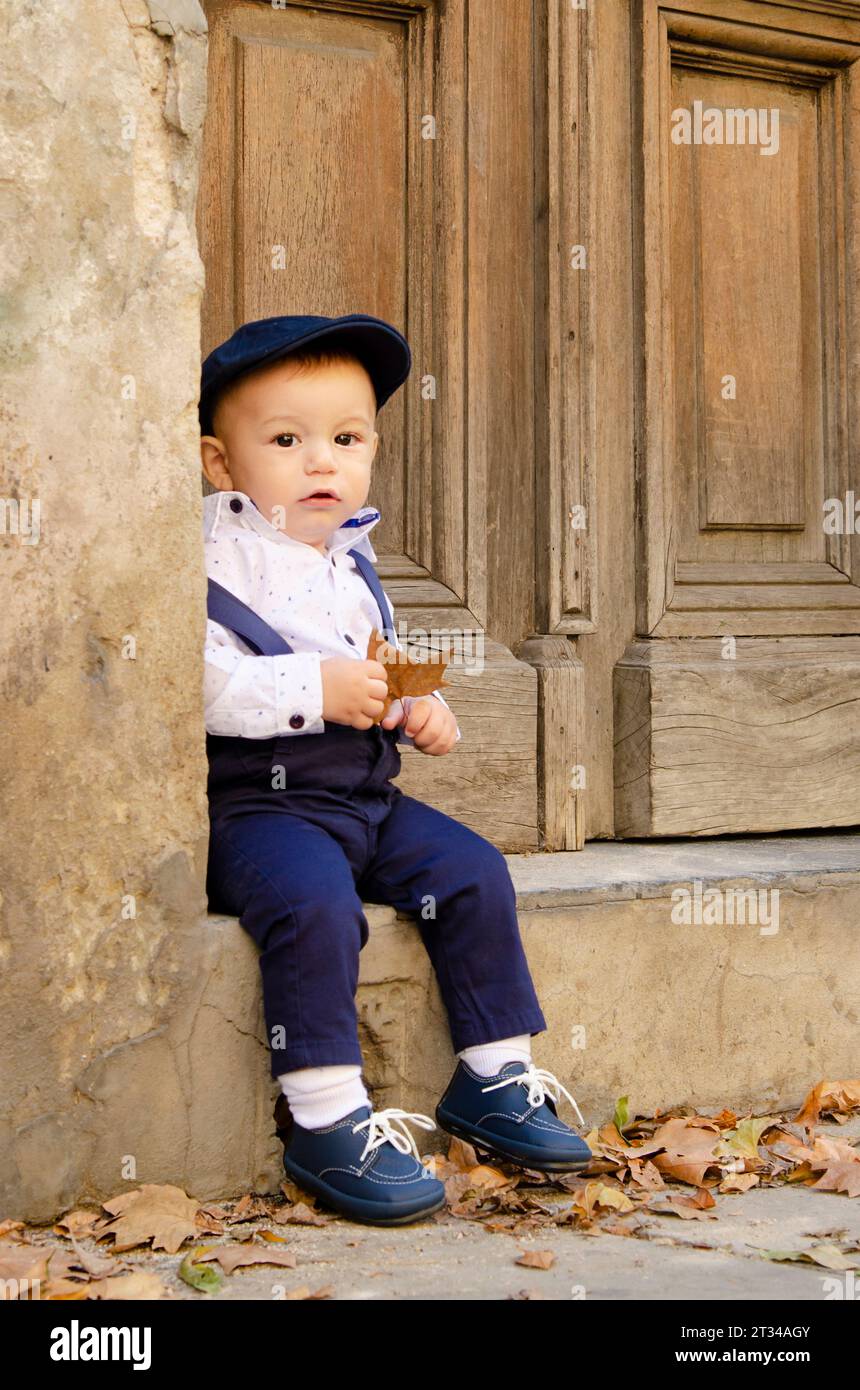 Boy sitting outside house hi-res stock photography and images - Alamy