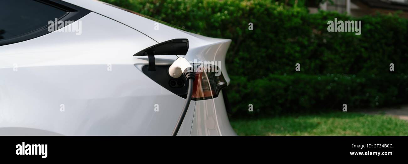 Closeup EV charger plug handle attached to electric vehicle port ...