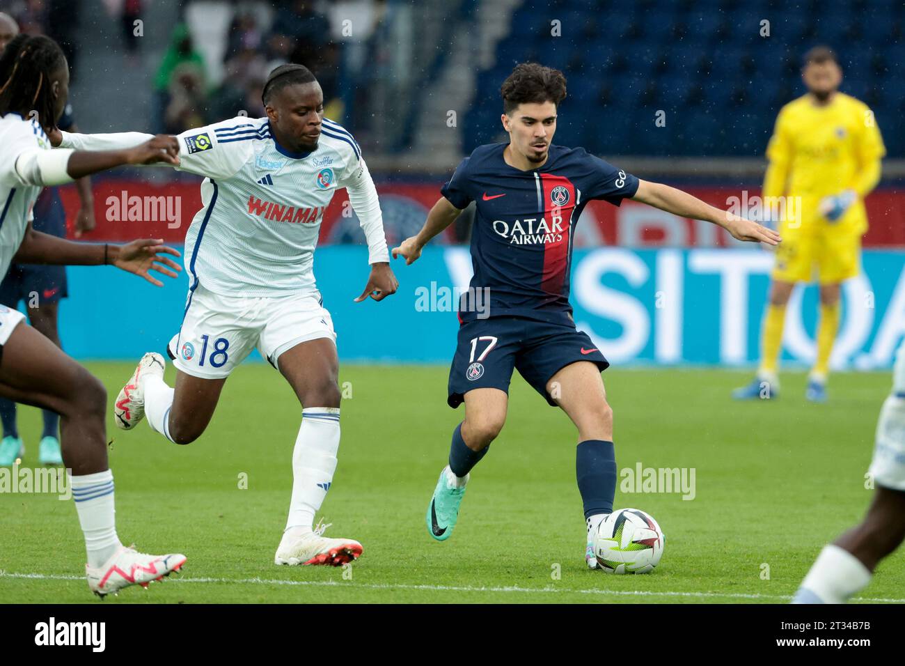 Paris, France. 21st Oct, 2023. Vitinha of PSG, left Junior Mwanga of Strasbourg during the ...
