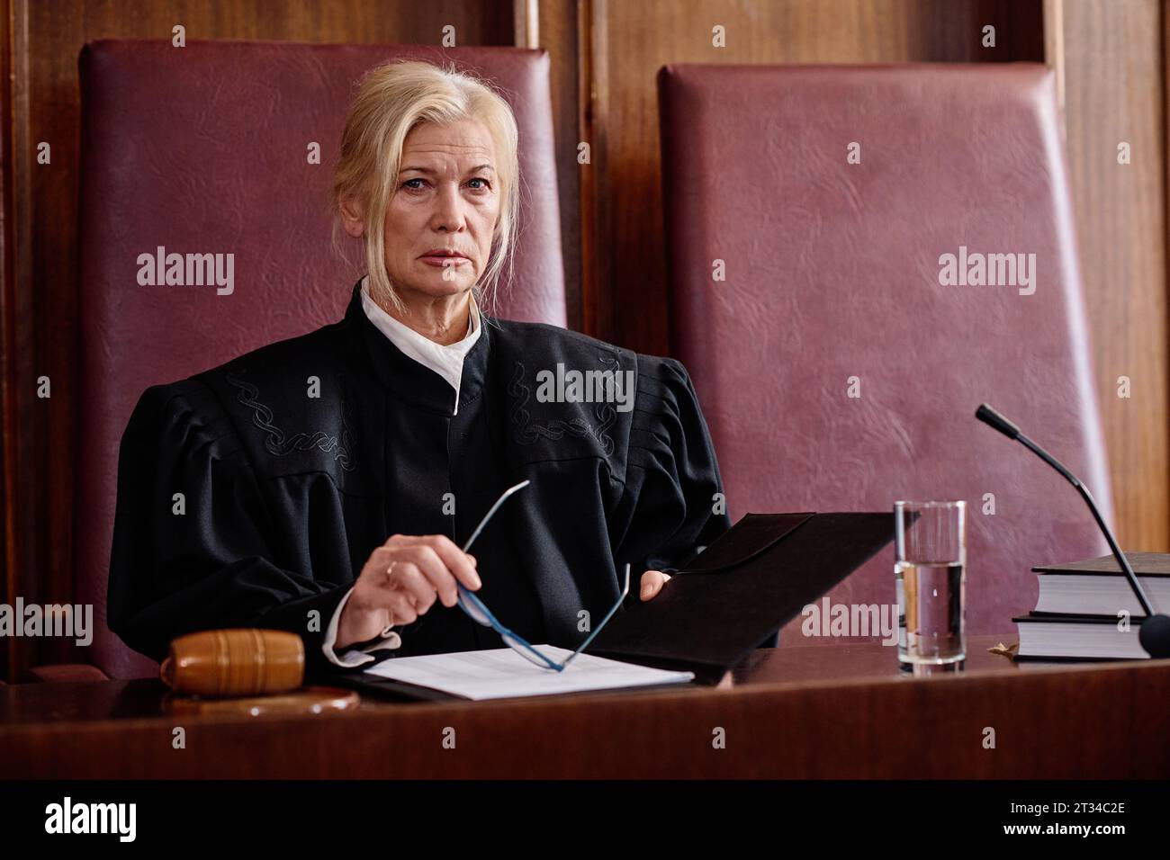 Serious mature blond female judge of supreme court of justice in black ...