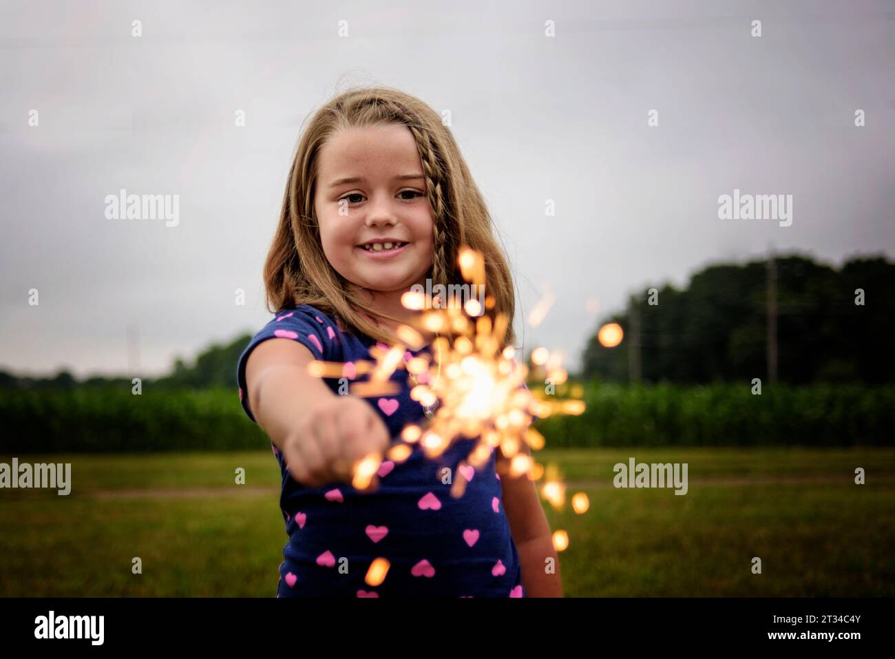 Little girl smiling with sparkler on Fourth of July Stock Photo - Alamy