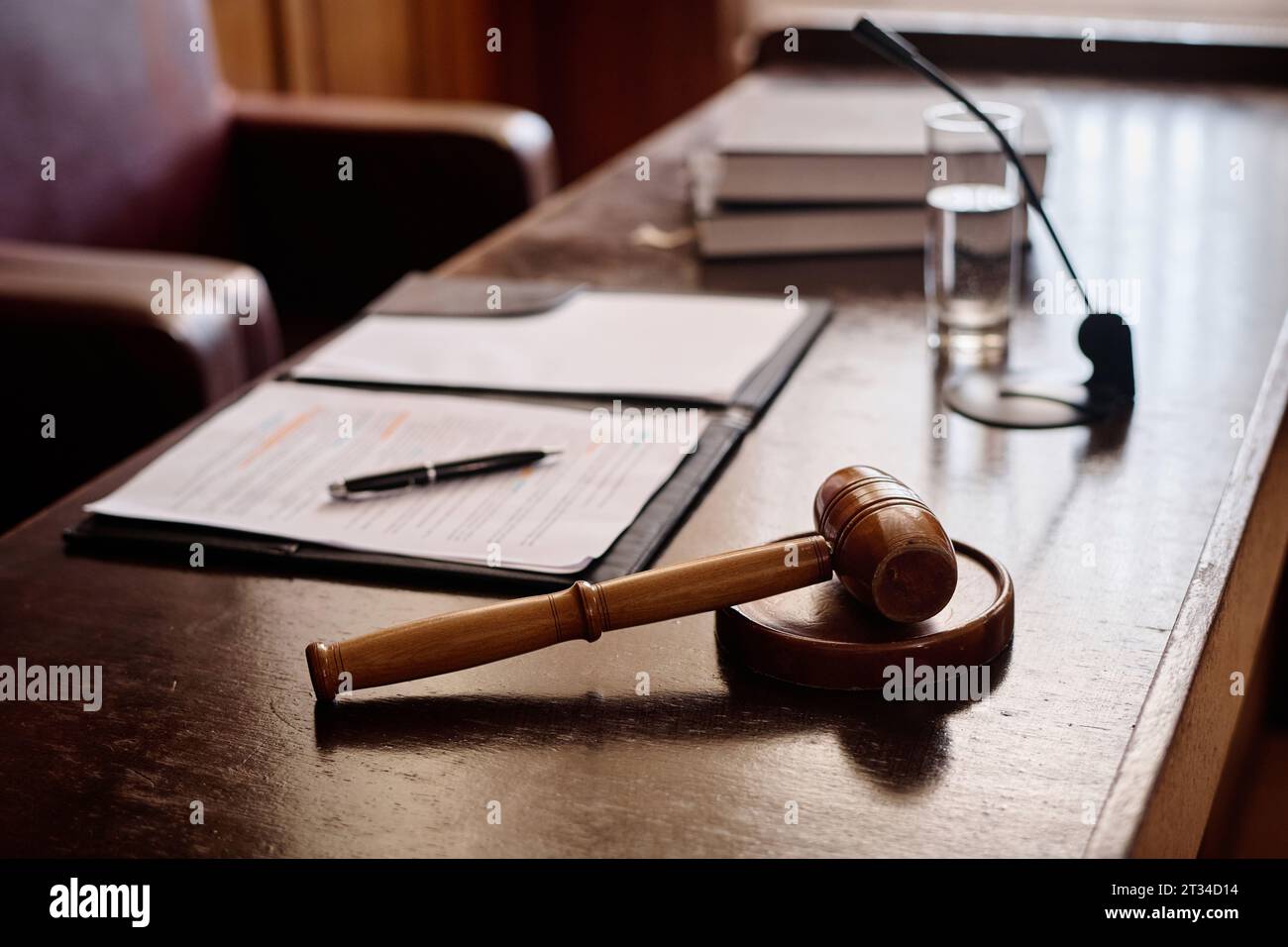 Wooden gavel on sounding block fixed on desk of judge with juridical ...