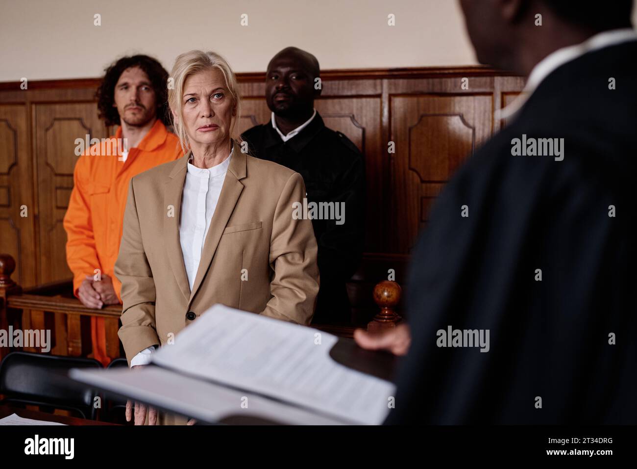 Focus on mature female attorney listening to impartial judge with open ...