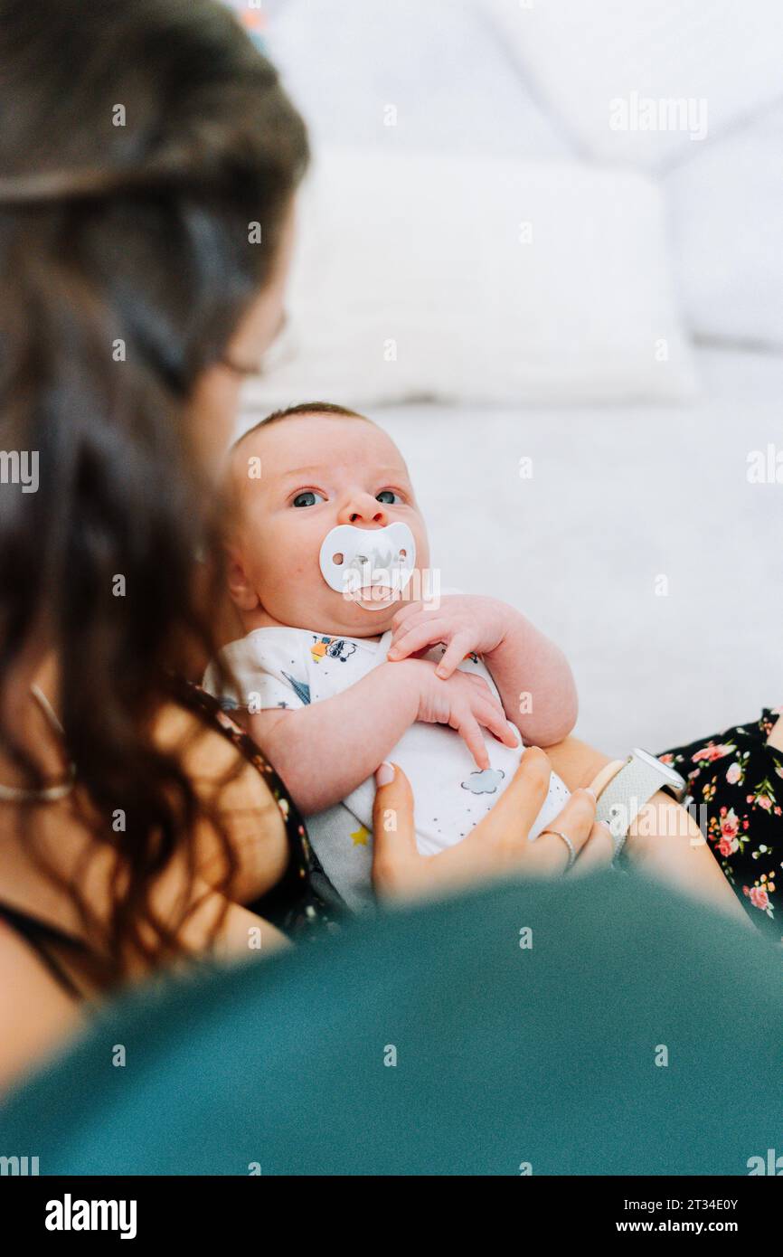 Portrait of a two weeks old newborn baby being cared of by his aunt ...