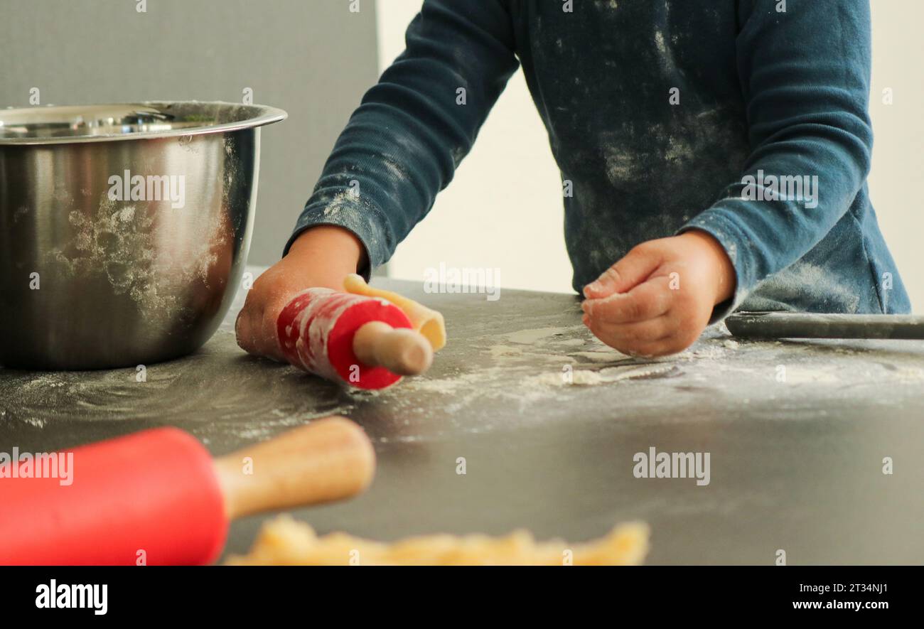 Close up of little boys hands making Christmas cookies at home. Red ...