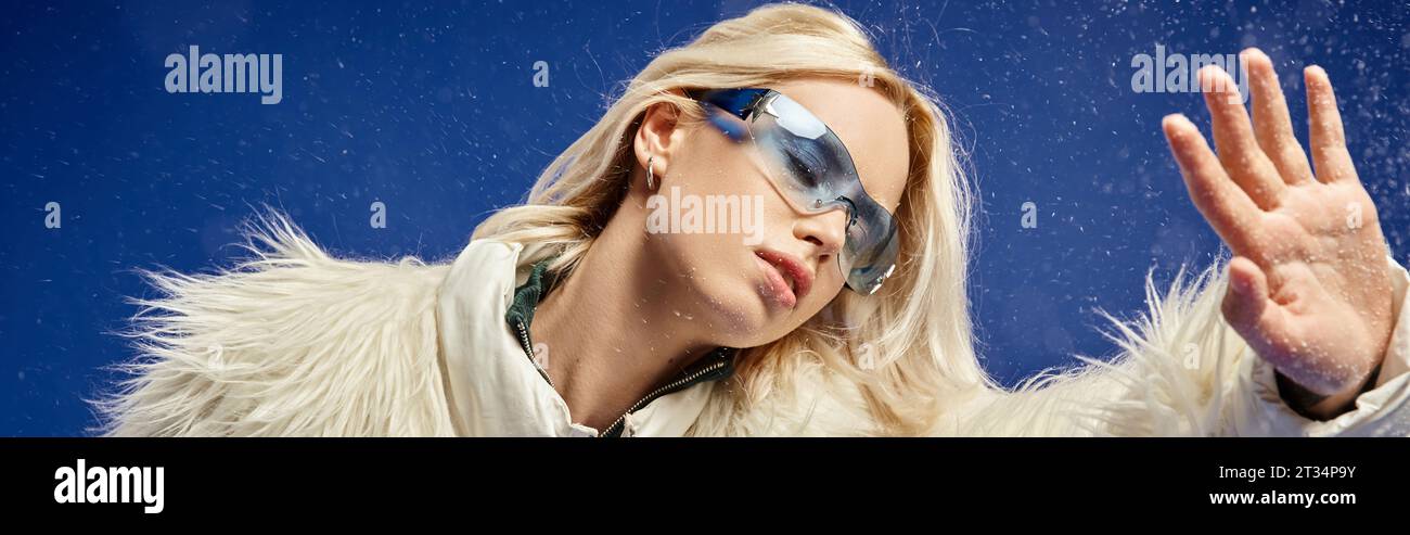 beautiful woman in faux fur jacket and sunglasses posing under falling ...
