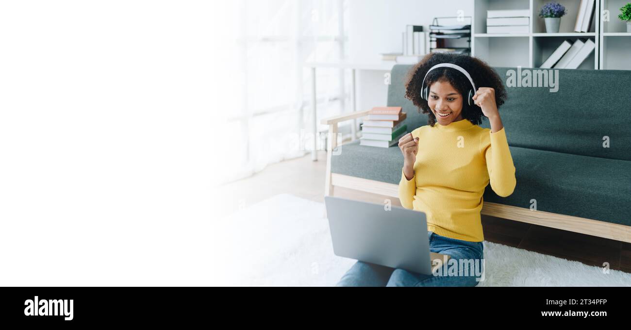 Happy young African American latina woman listening to music using ...