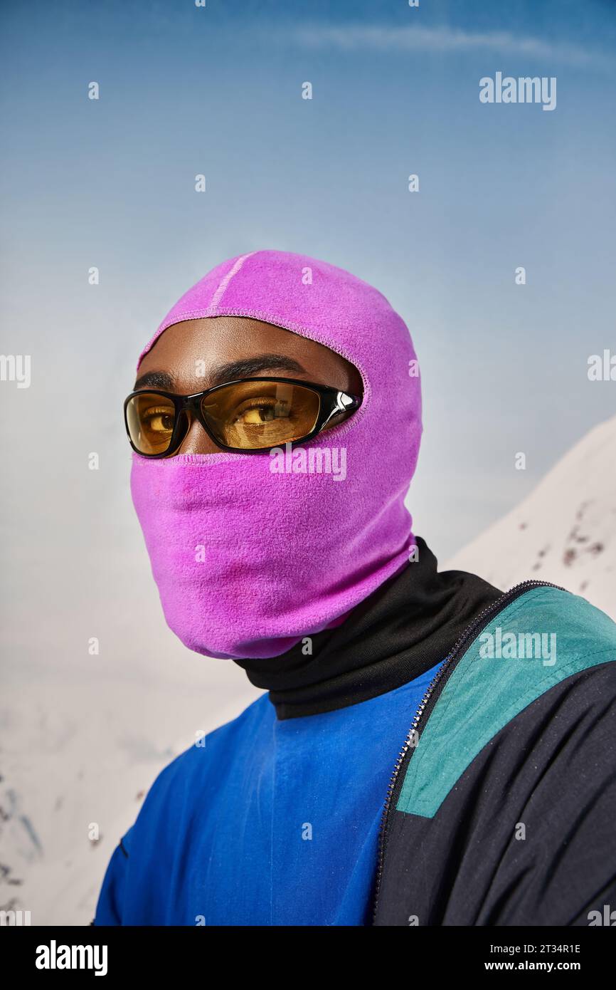young african american man in pink balaclava and sunglasses looking at ...