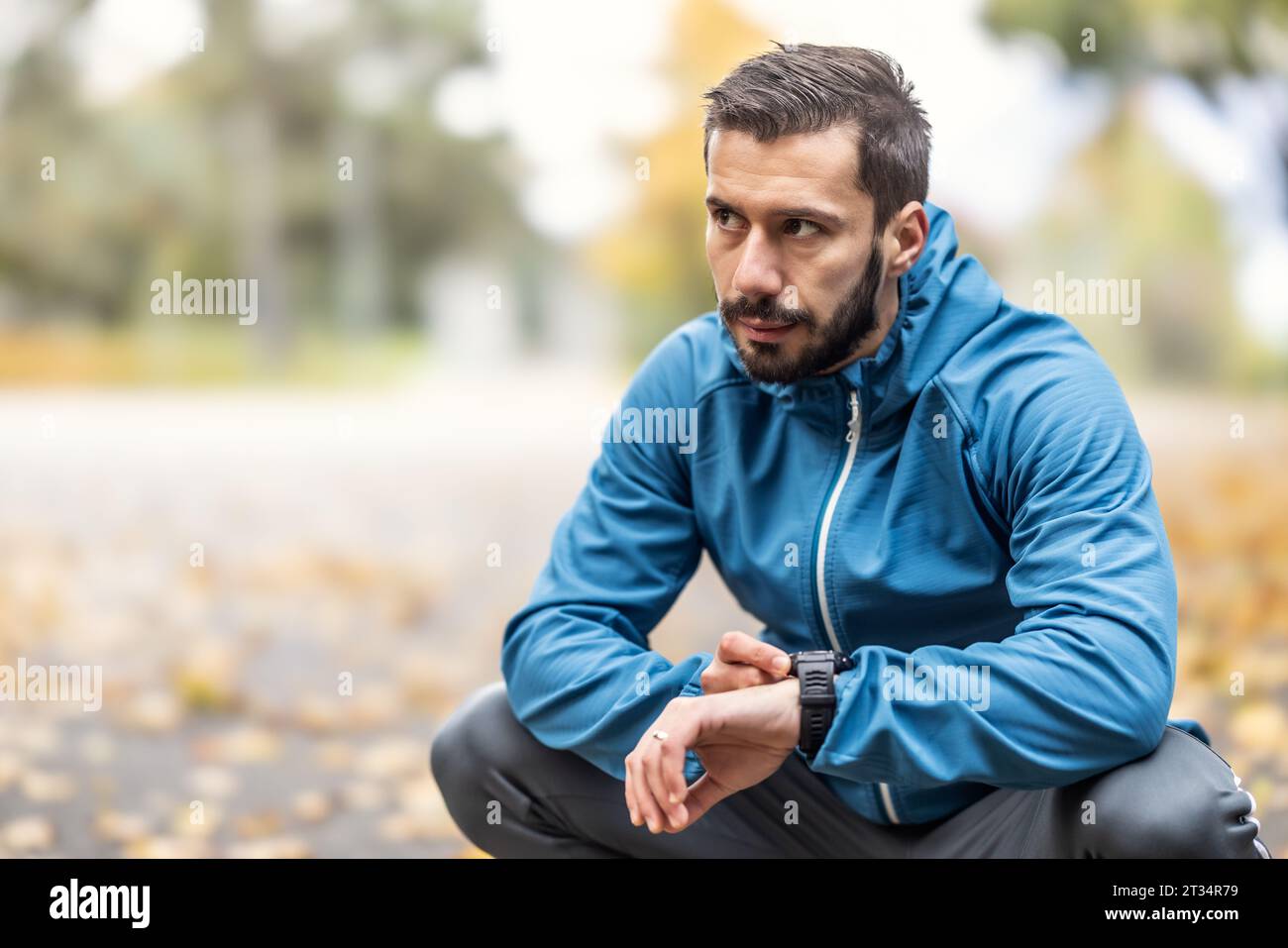 A good-looking sportsman checks the measured values on a sports watch ...