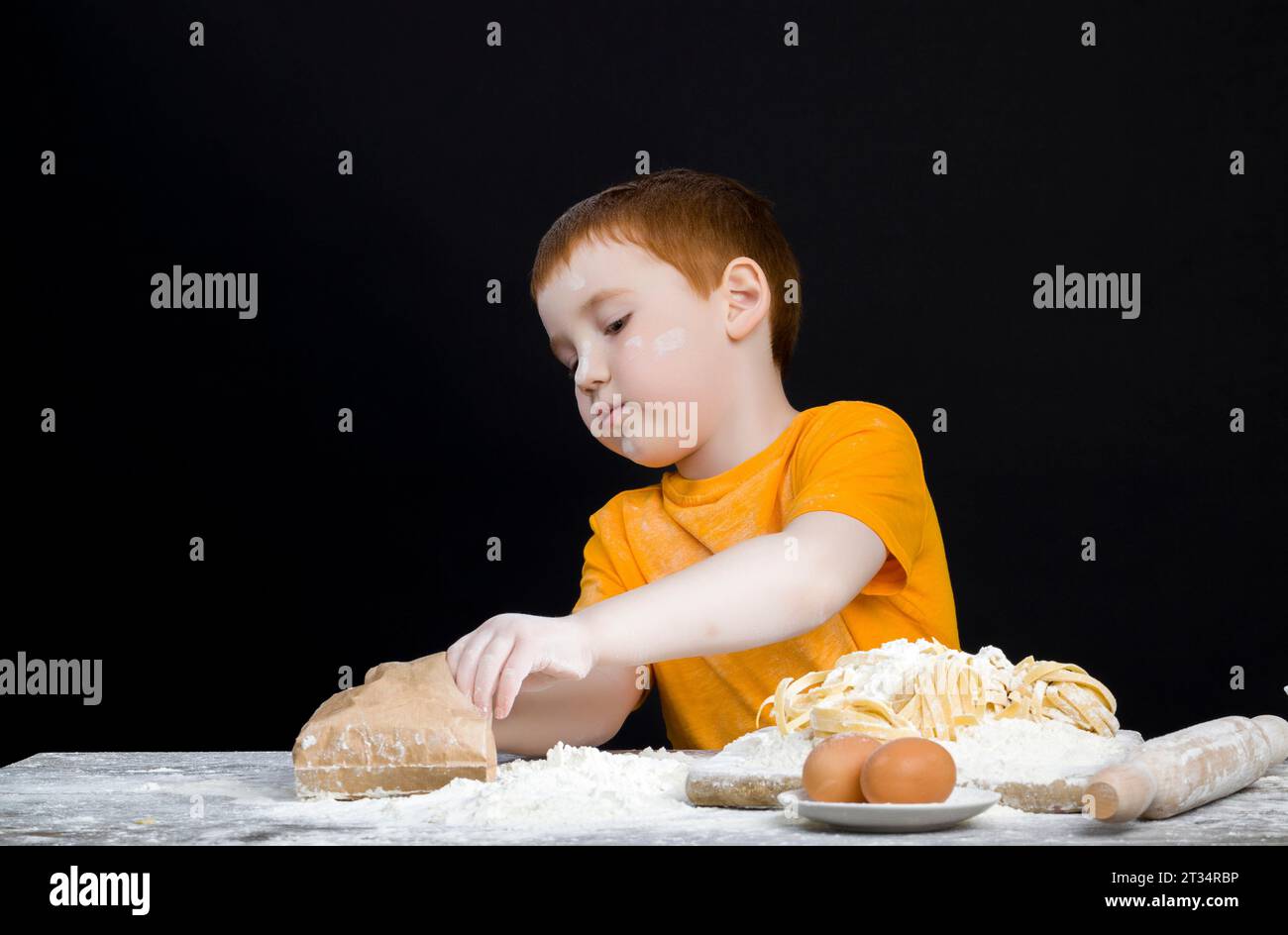 baby boy in the kitchen while helping with cooking, beautiful boy with ...