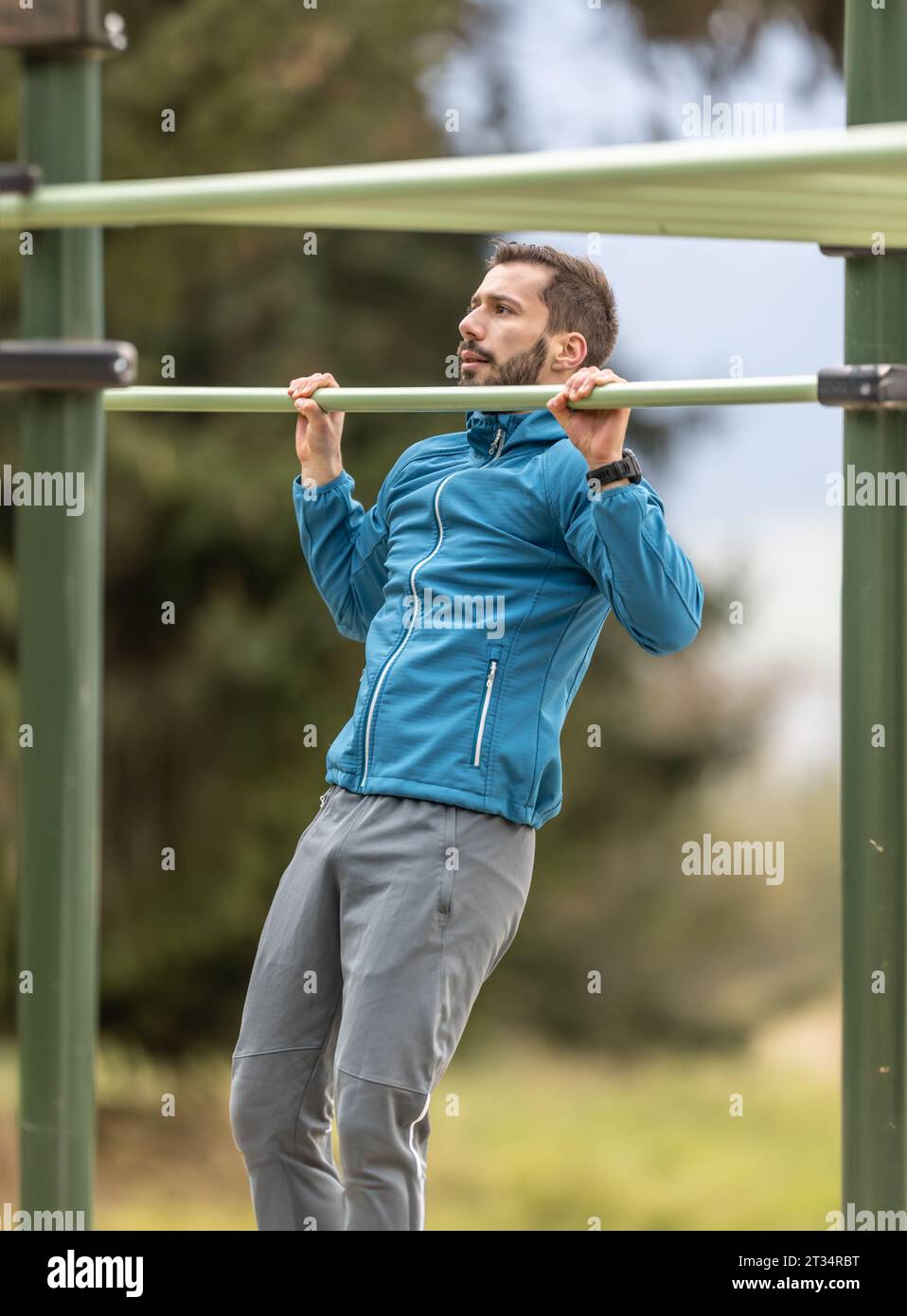 Young man working out calisthenics in an outdoor gym using parallel ...