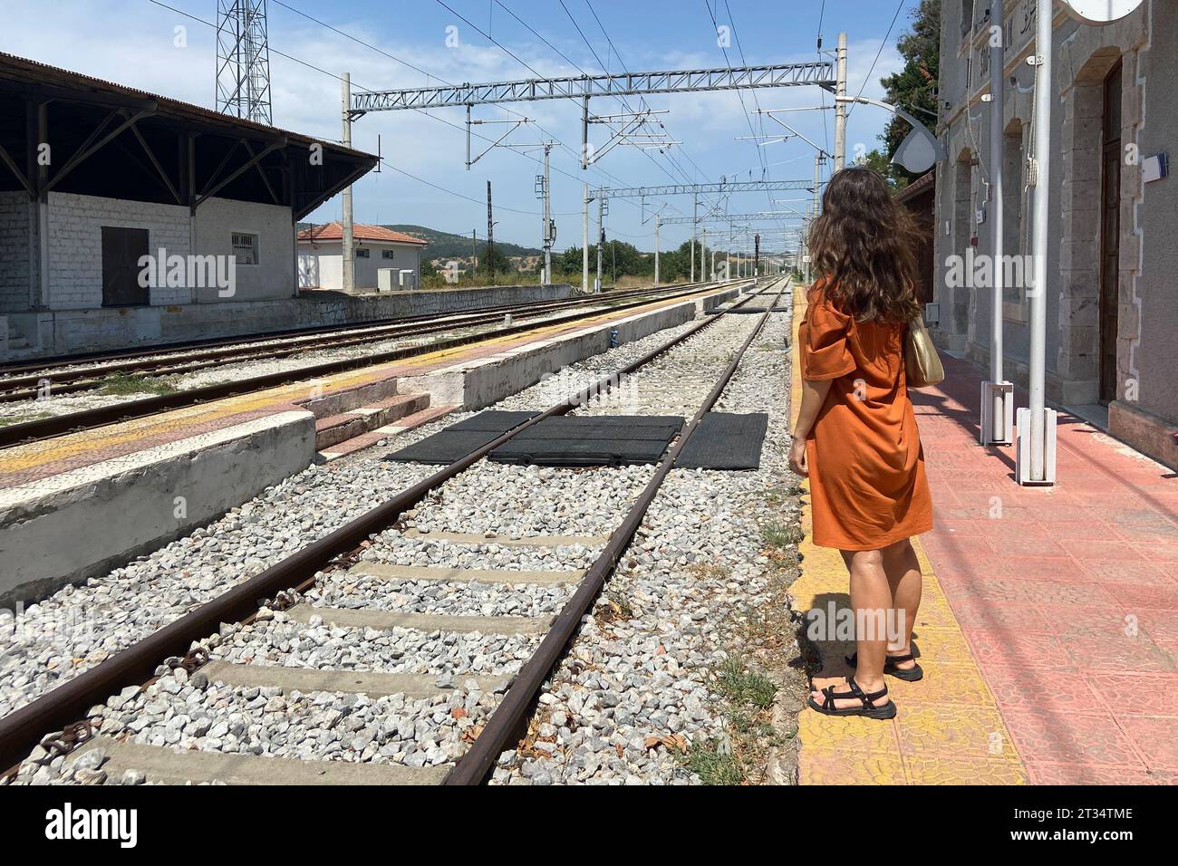 Girl on the platform of a railway station in the village waiting for or ...