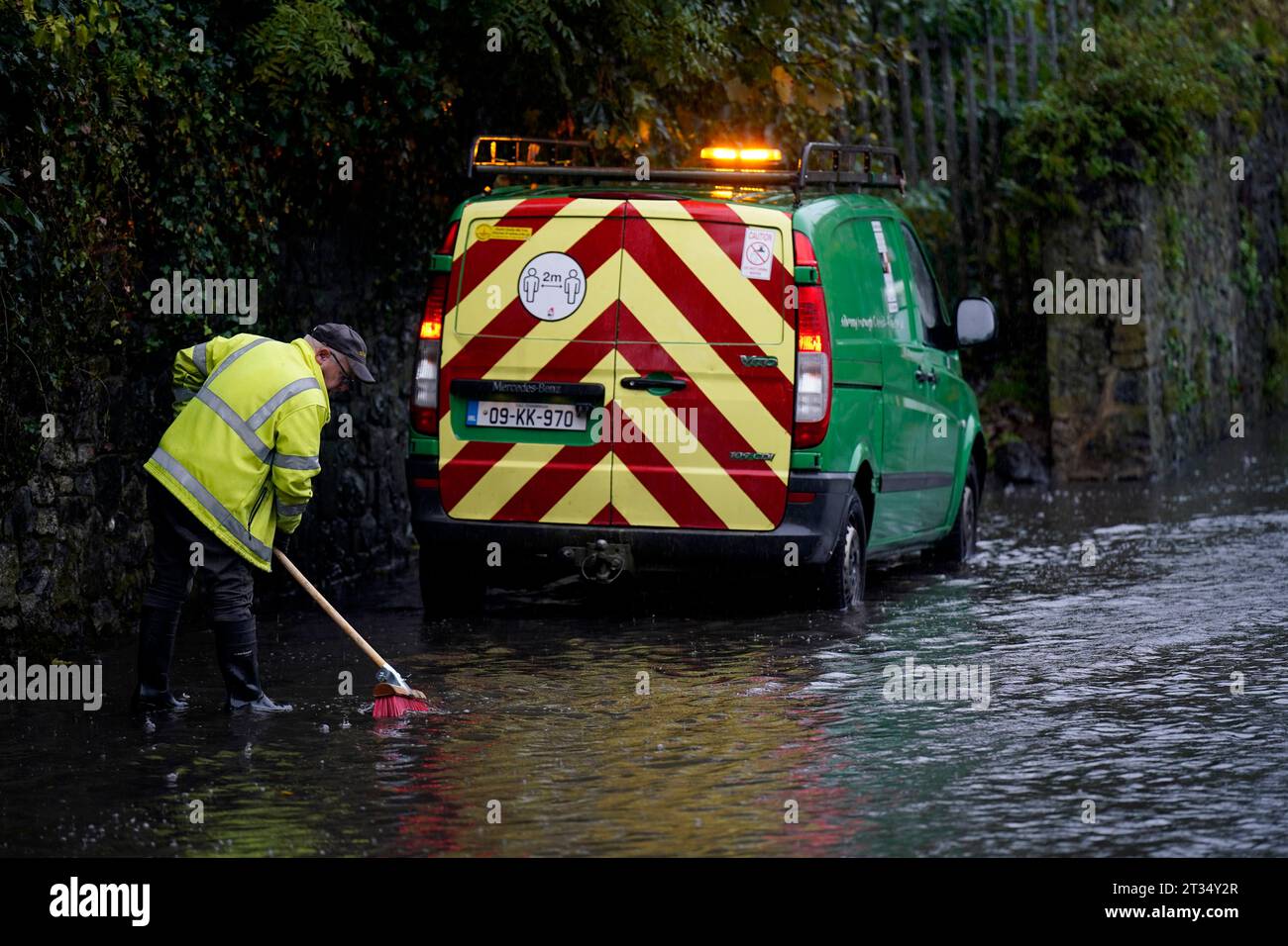 A local authority worker clears a road gully in Co. Kilkenny, Ireland ...