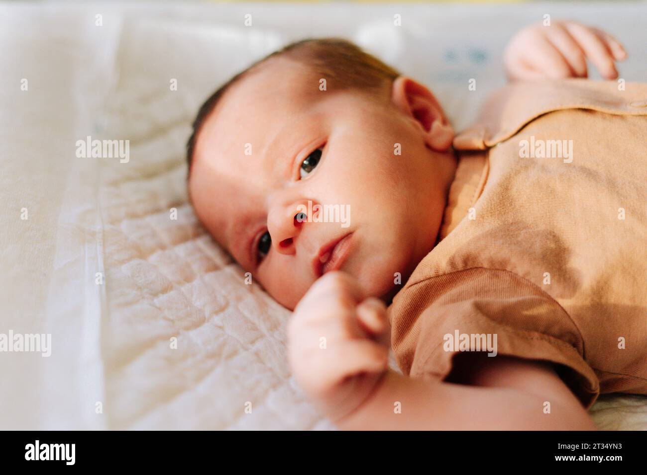 Portrait of a two weeks old newborn baby on a baby changer Stock Photo ...