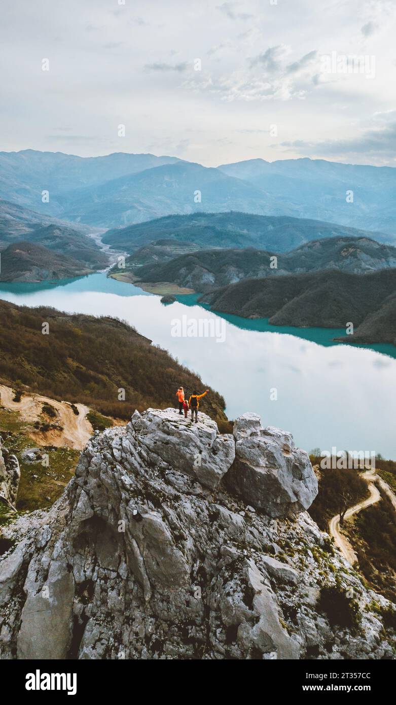Family hiking outdoor travel people on cliff mountain aerial lake view ...