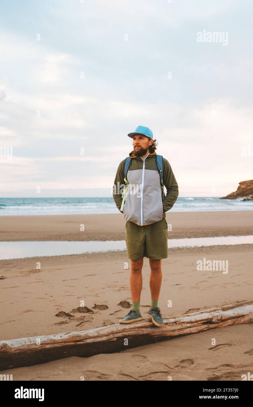 Man standing alone on the beach travel lifestyle active summer ...