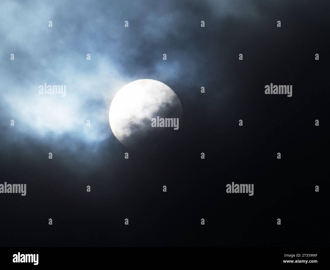 Cloud drifting past the sun with visible sun spots over Ambleside, Lake ...