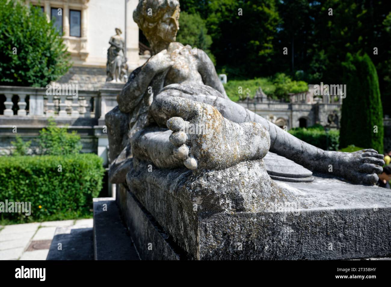 Female weathered garden statue, the angle emphasizing her graceful feet ...