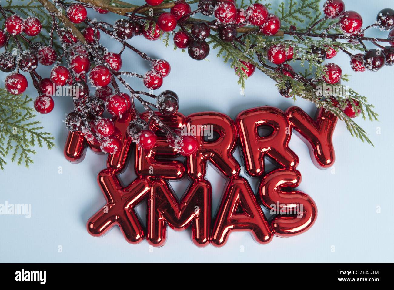 A glossy red plastic Christmas ornament featuring a text saying merry ...