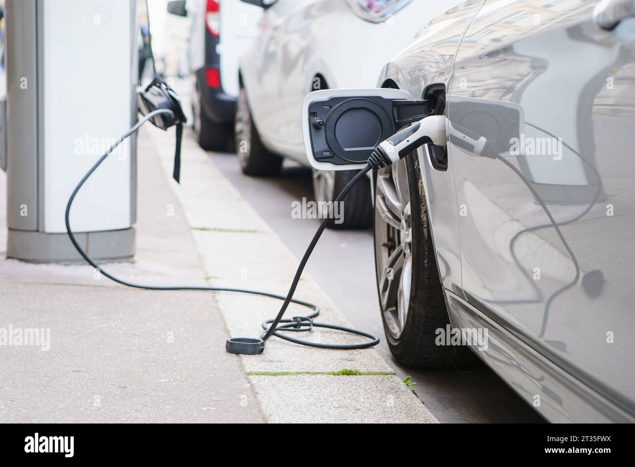 Electric car charging in the city street. Modern co2 neutral vehicle on ...