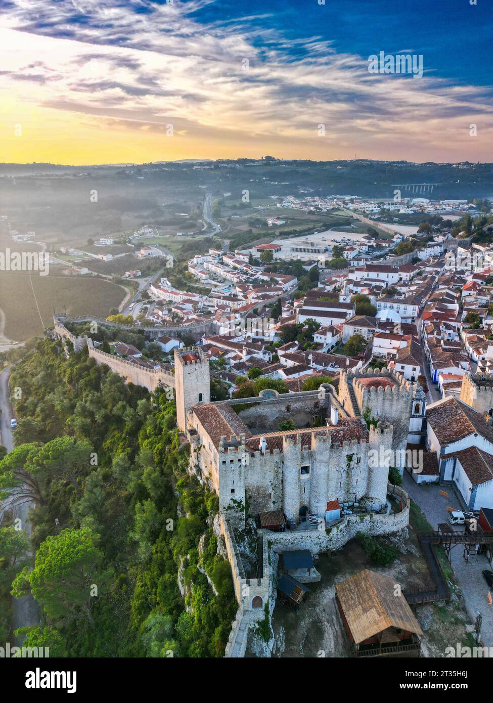 An aerial view of a quaint medieval town with a stunning sunset ...