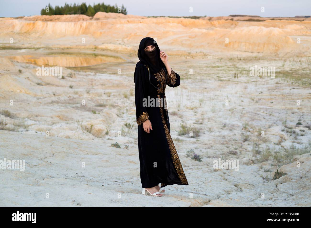 Muslim woman walking the desert area around the city Stock Photo - Alamy