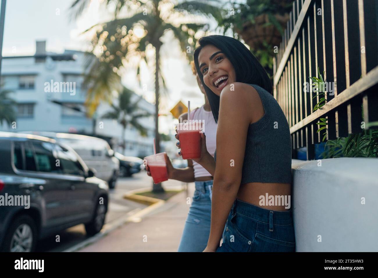 USA, Florida, Miami Beach, two happy female friends having a soft drink ...