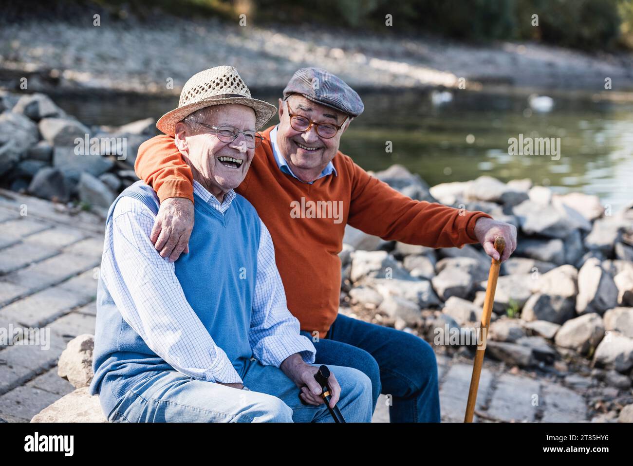 Two old friends sitting by the riverside, having fun Stock Photo - Alamy