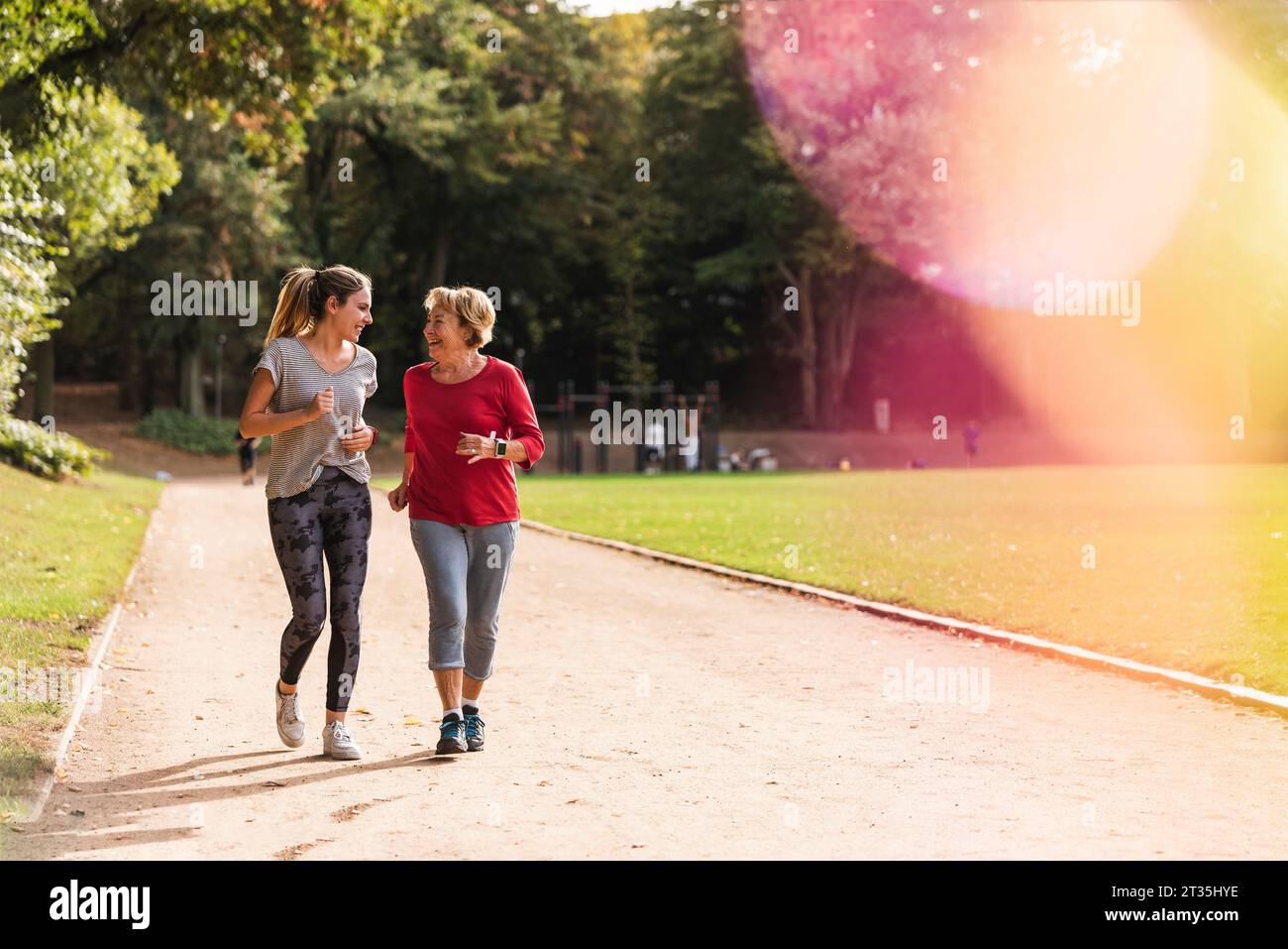 Granddaughter and grandmother having fun, jogging together in the park ...