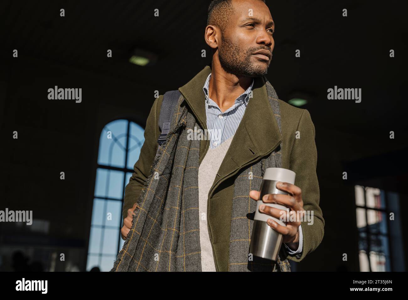 Stylish man with reusable cup getting out of the train station Stock ...