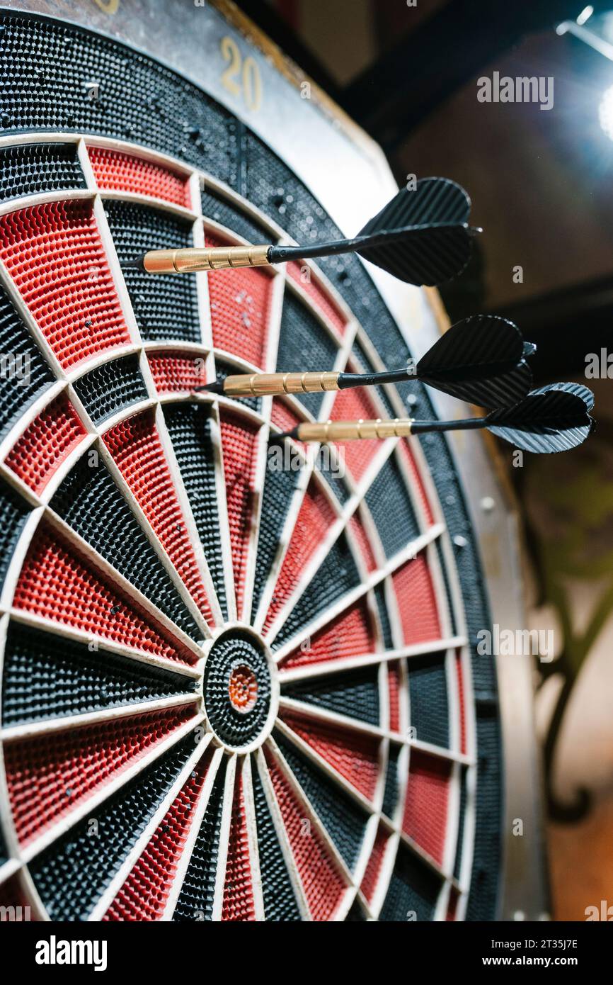 Three black darts hitting the dartboard in bar Stock Photo - Alamy