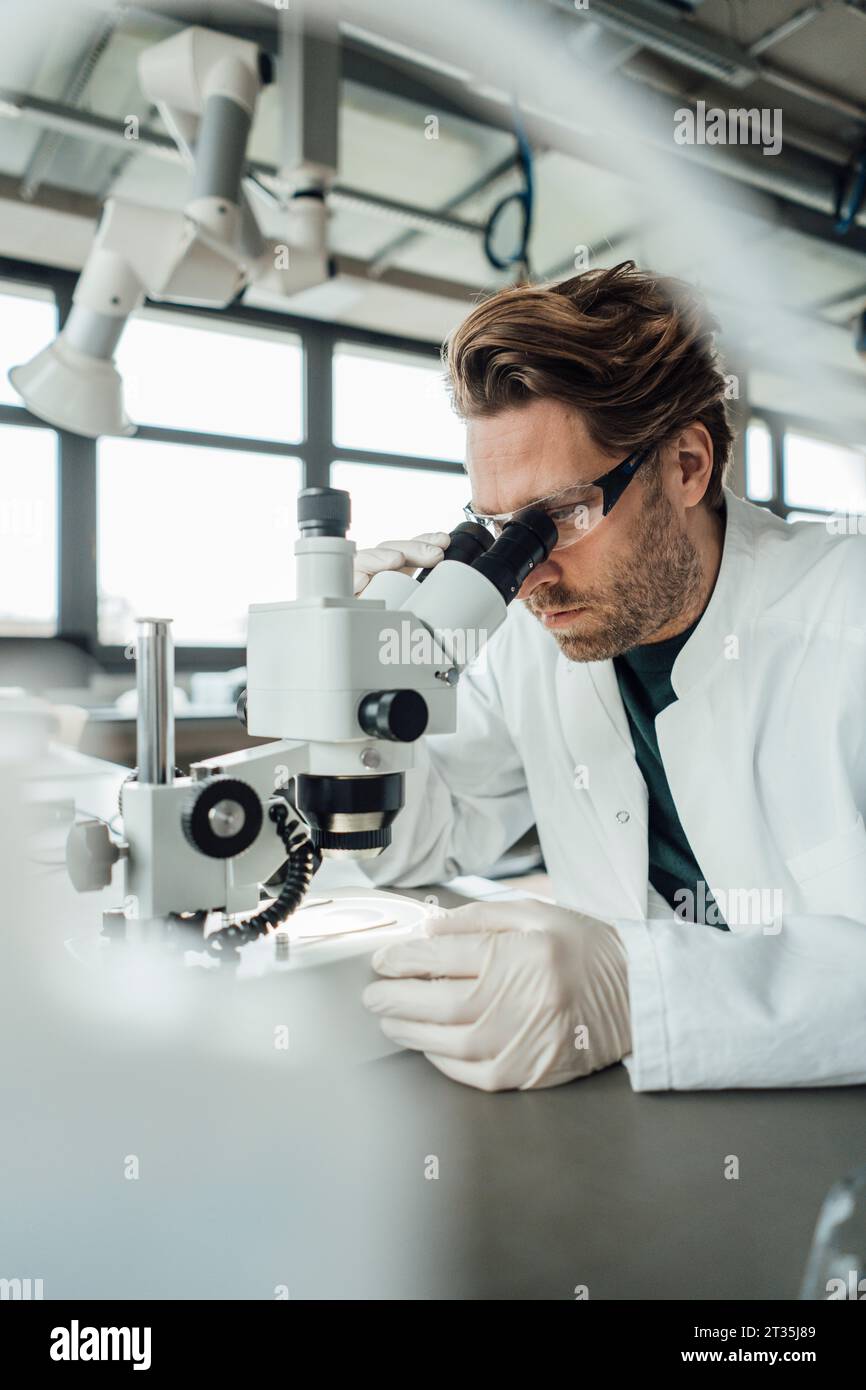 Male scientist working microscope in hi-res stock photography and ...